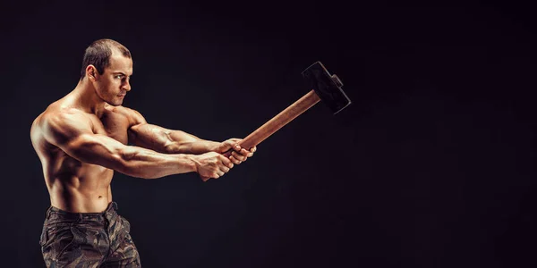 Muscular man with naked torso holding big hummer. Isolated on dark grey ...