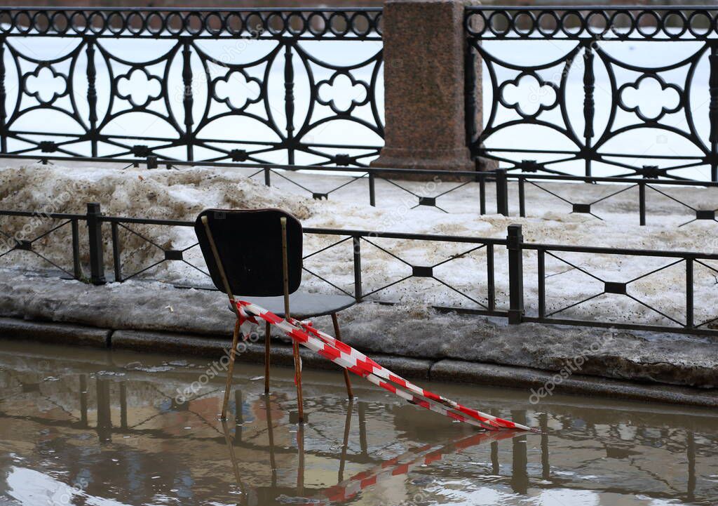 Una vieja silla oxidada con un pedazo de cinta roja y blanca se ...