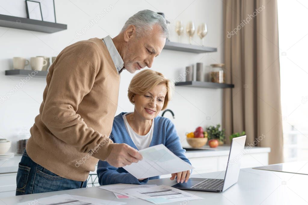 Pareja de mediana edad chequeando cuentas financieras juntos. Esposa y ...