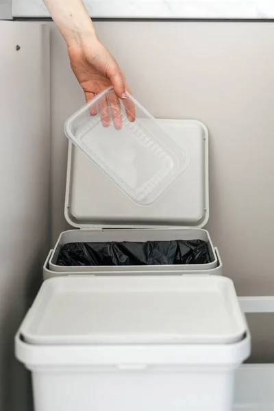 Cropped view of woman throw plastic container in recycling bin in ...
