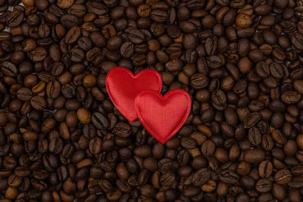 red heart and an inscription of letters on a background of coffee beans. Love coffee concept. St ...