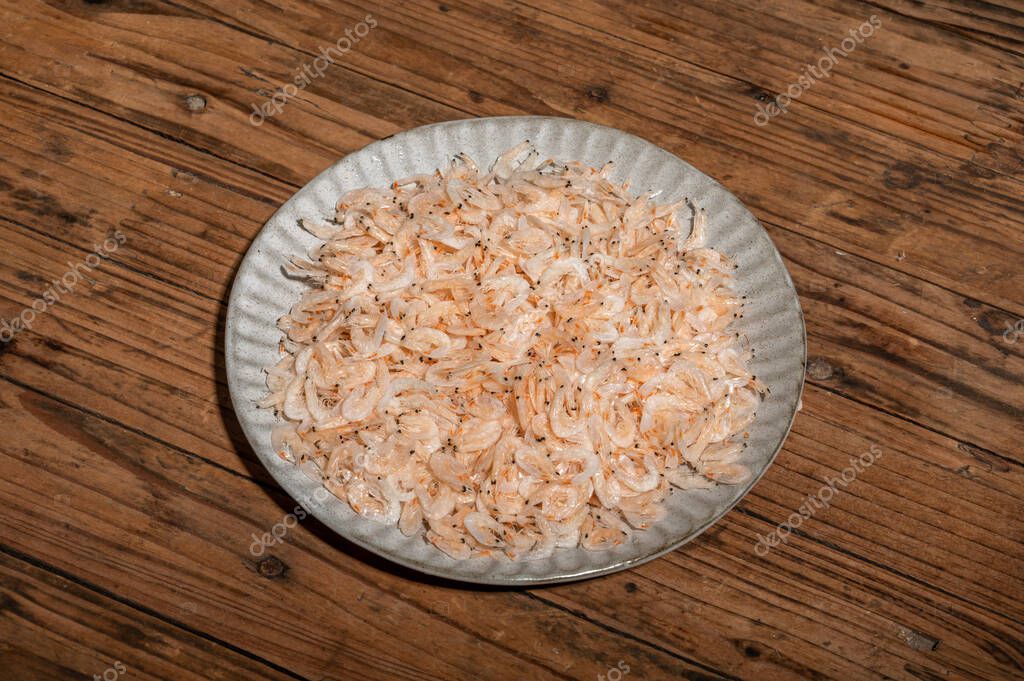 Los peque os camarones secos en el taz n o plato est n en la mesa de ...
