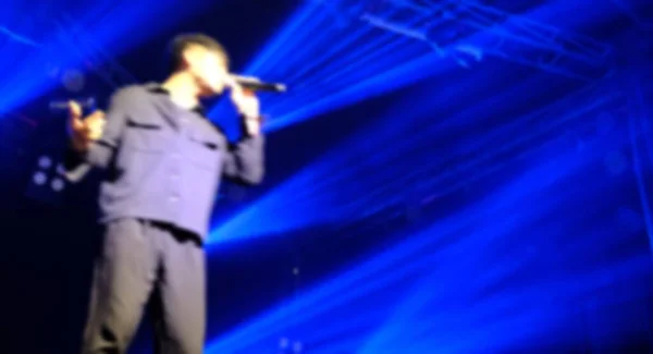 A male singer with a mic facing forward singing on stage Stock Photos ...