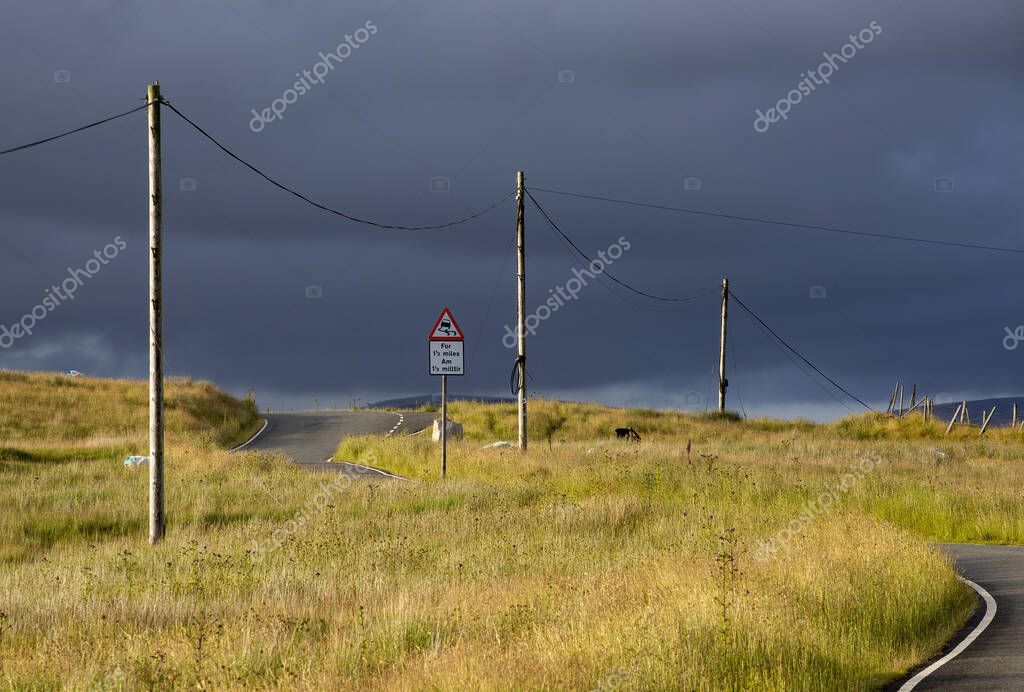Una señal de tráfico bilingüe en inglés y galés y postes de servicios ...