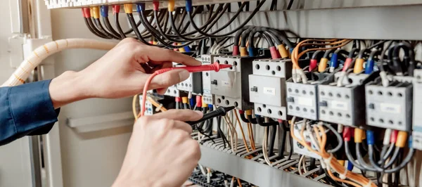 Electrician engineer uses a multimeter to test the electrical ...