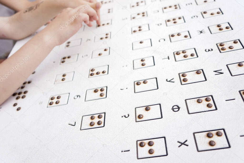 La mano de un niño está leyendo Braille. La mano del niño lee Braille ...