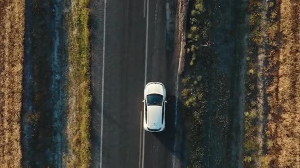 Road trip concept. Top view drone tracks modern white car moving fast ...