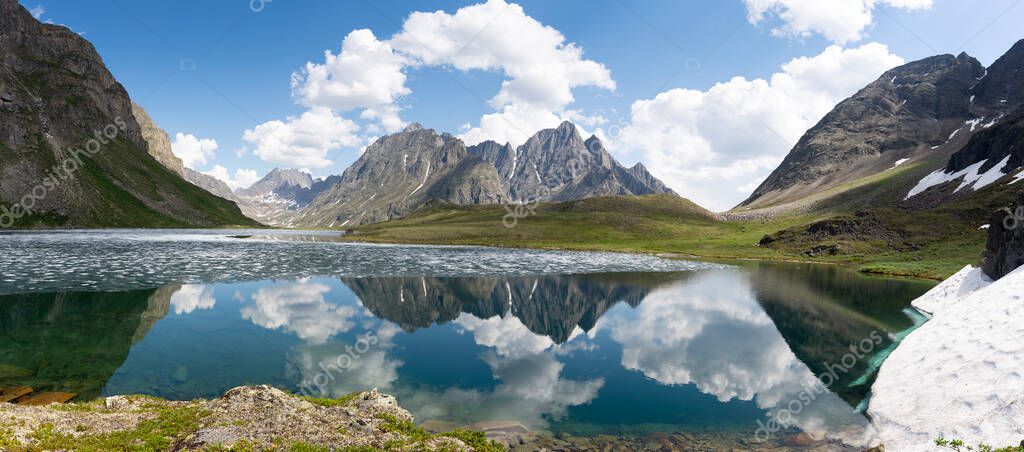 Un hermoso lago de montaña sobre el fondo de las montañas Kodar ...