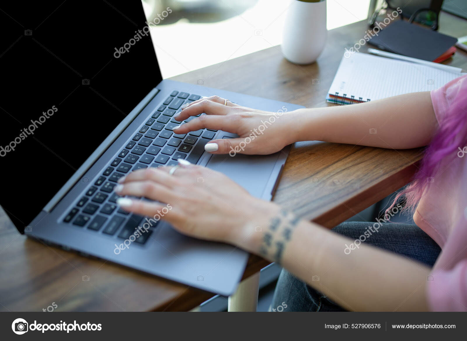 Back view of a young pink hair woman keyboarding on laptop computer ...