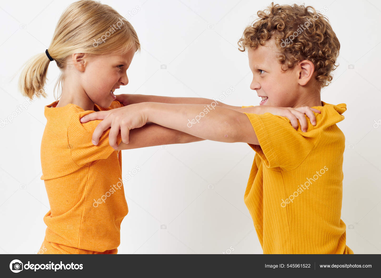 Two joyful children in yellow t-shirts standing side by side childhood ...