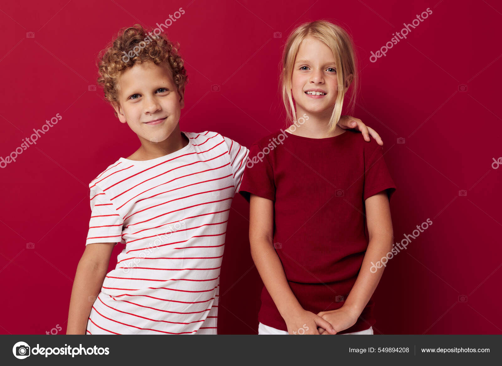 Two joyful children emotions stand side by side in everyday clothes on ...