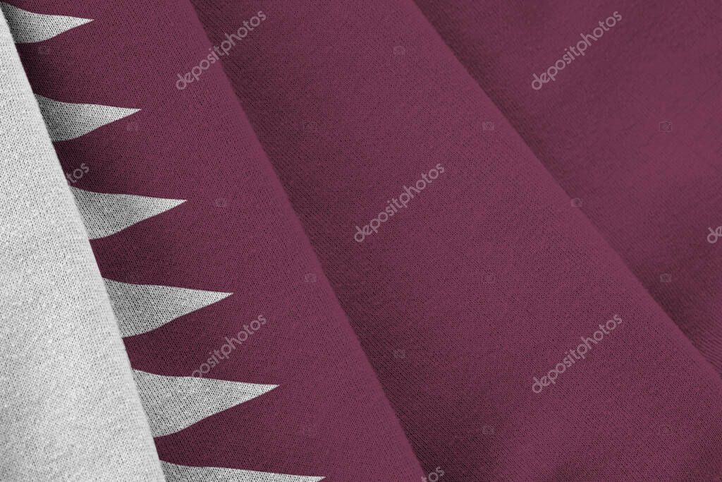 Bandera de Qatar con grandes pliegues ondeando de cerca bajo la luz del ...
