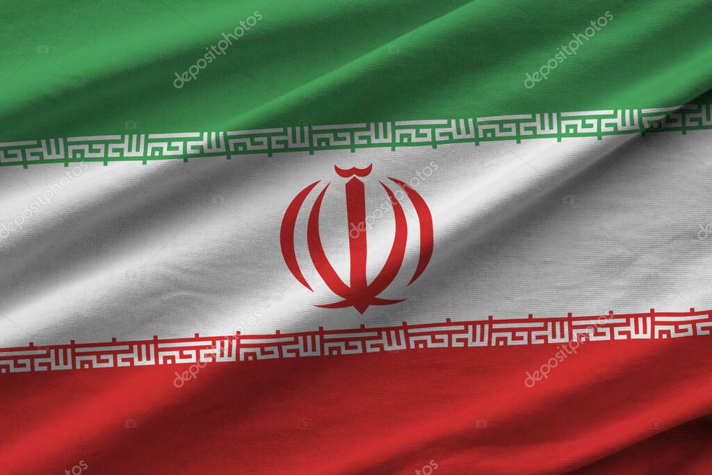 Bandera de Irán con grandes pliegues ondeando de cerca bajo la luz del ...