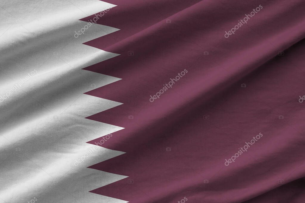 Bandera de Qatar con grandes pliegues ondeando de cerca bajo la luz del ...