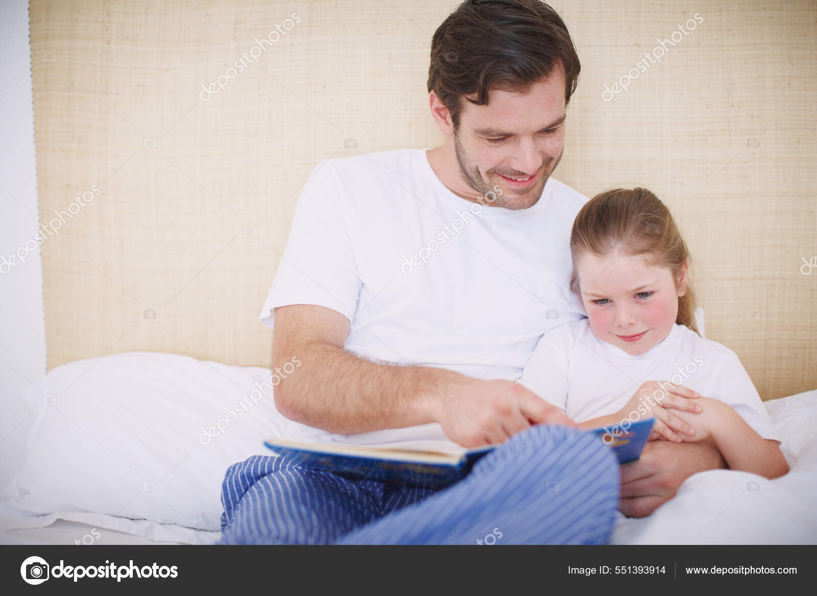 Looking at all the pictures. Shot of a devoted father reading his young ...