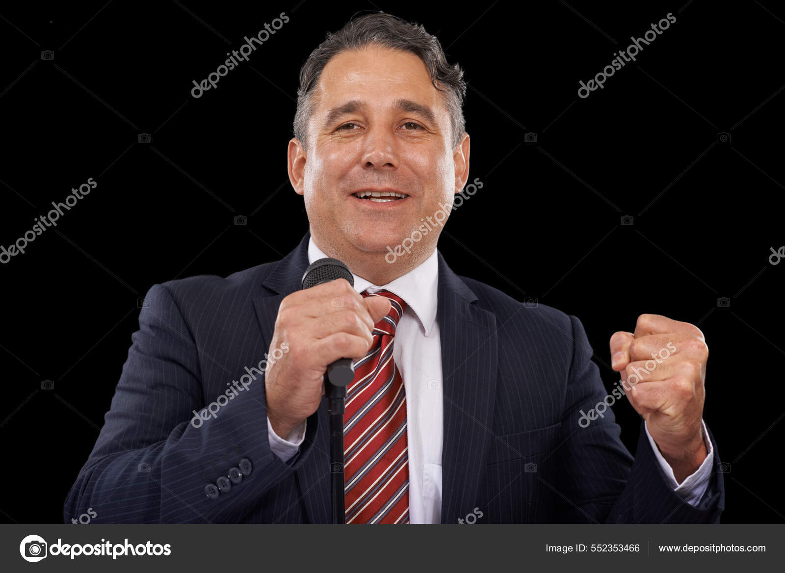 Getting his point across. A man in a suit giving a speech while holding ...