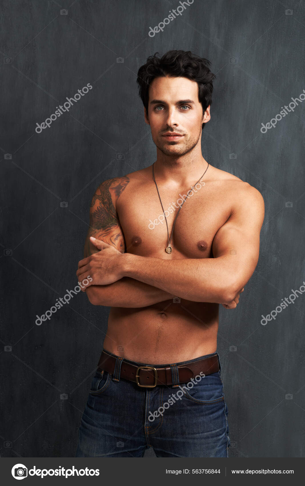 Confident and buff. A shirtless young man standing with his arms folded ...