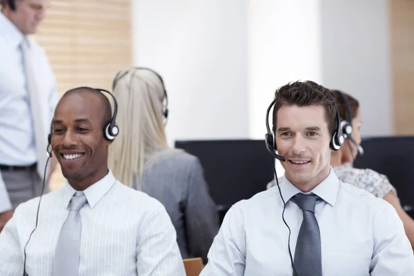 Two handsome customer service representatives sit and work with ...