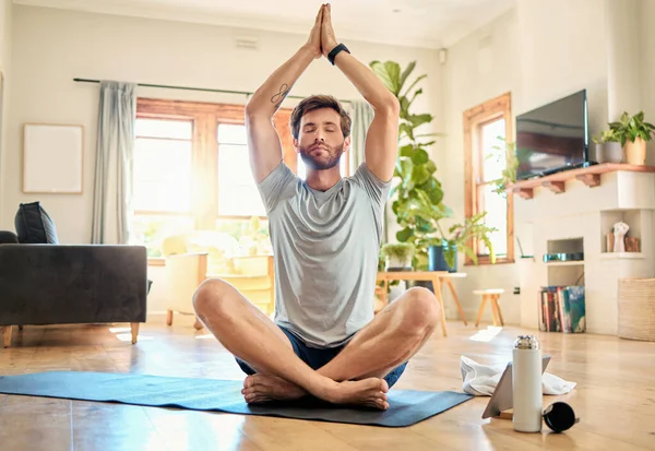 One young caucasian man sitting with legs crossed and eyes closed ...