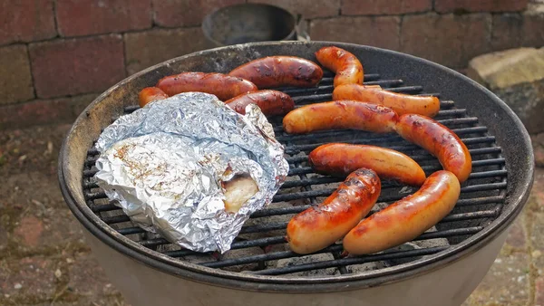 Food stuff. Sizzling barbecue sausages and chicken wrapped in foil ...