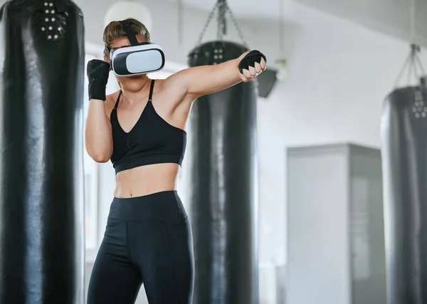 Healthy, fit and active boxing woman with a VR headset to access the ...