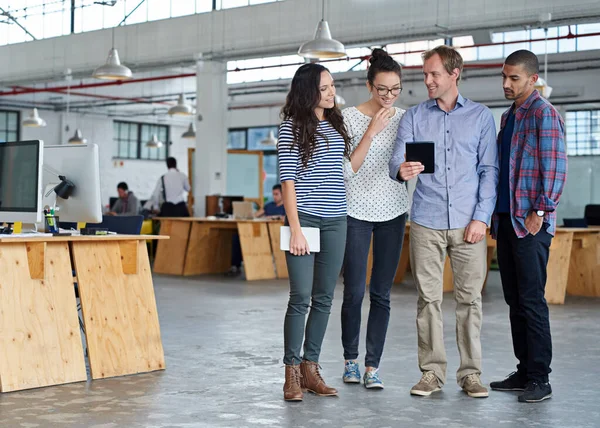 All the latest on the go. Open plan office with group of staff standing ...