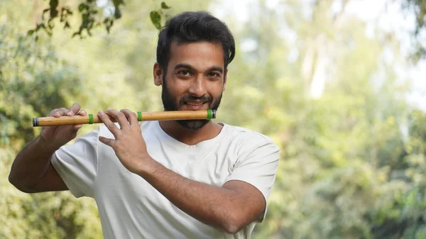 Bansuri player playing music in sunshine at Park - Indian Flute Player ...
