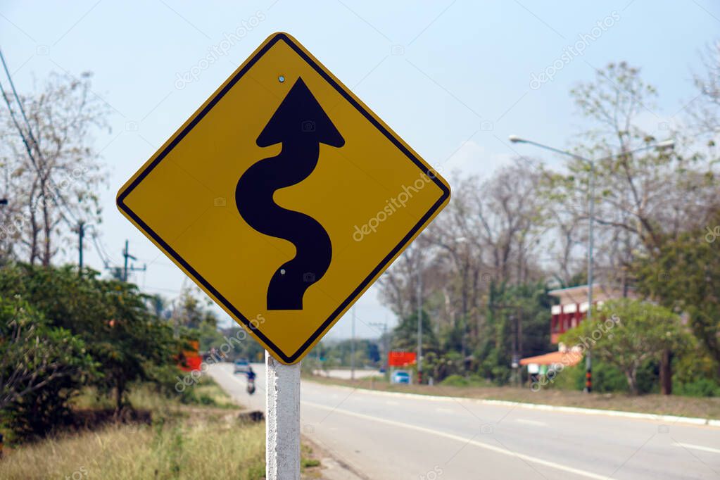Señal de tráfico amarillo con símbolo de flecha retorcida en la ...