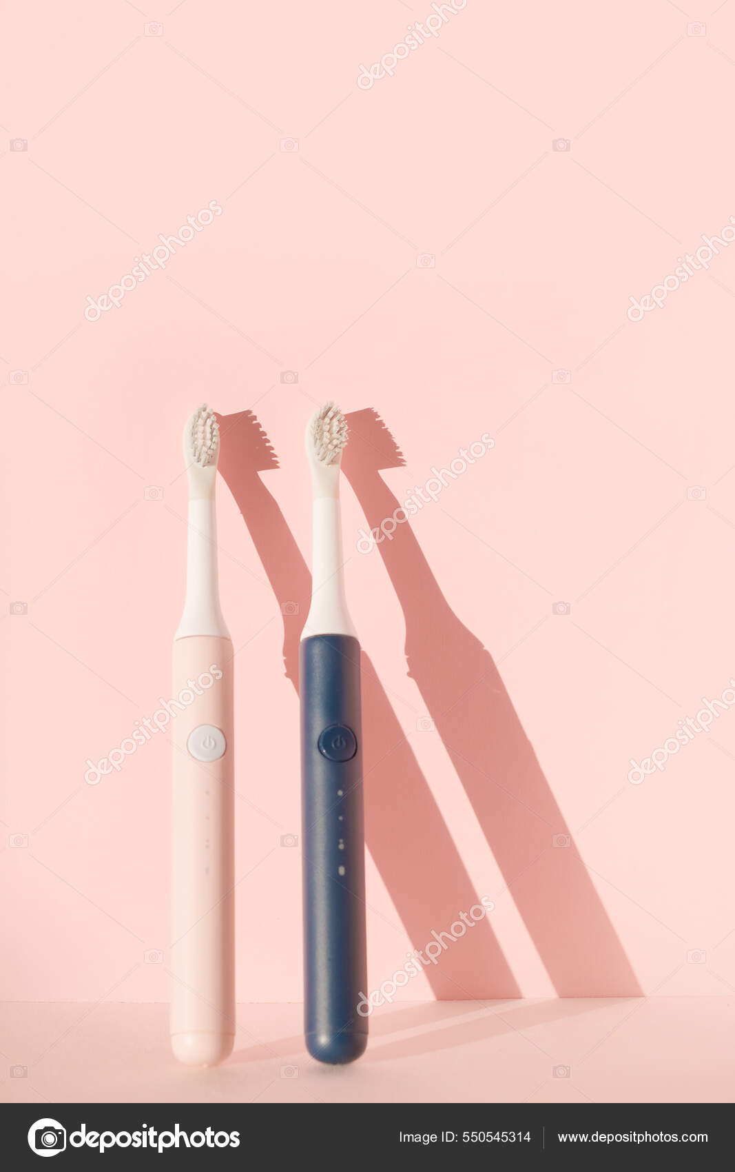 Two new modern ultrasonic toothbrushes. Dental care supplies on pink ...