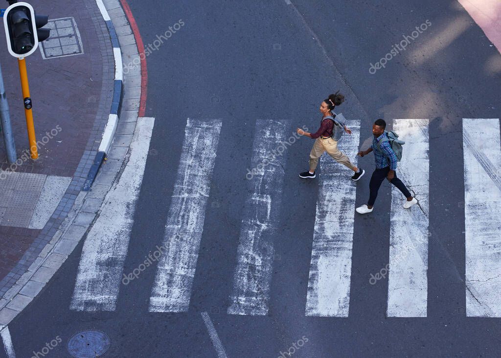 Dos jóvenes peatones cruzan la calle en un paso de peatones en la ...
