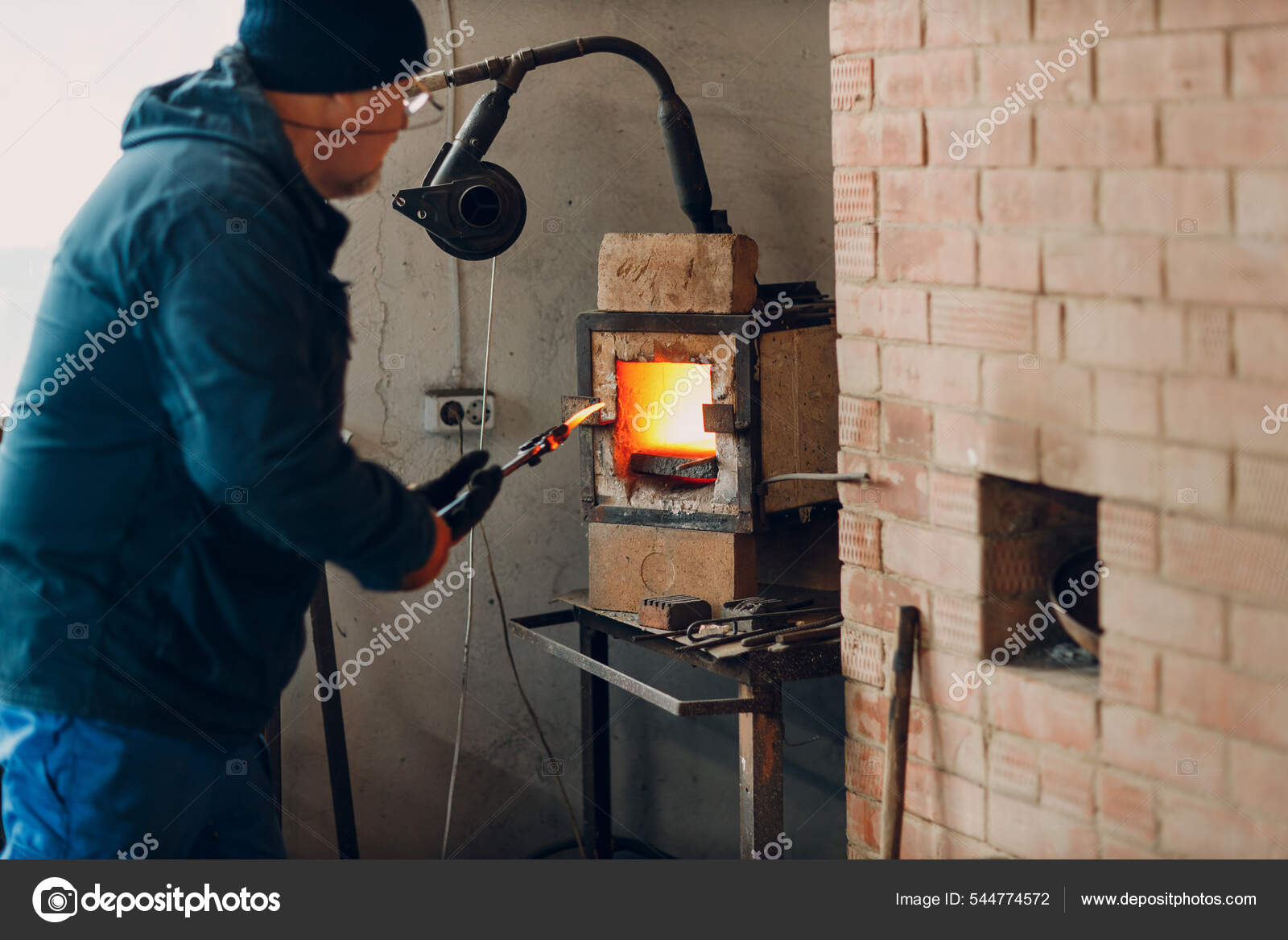 Blacksmith forge oven with hot flame. Smith heating iron piece of steel ...