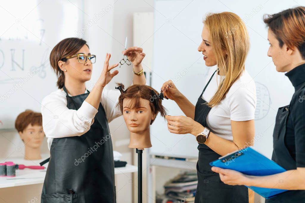 Manos de un peluquero sosteniendo tijeras de peluquería, explicando a ...