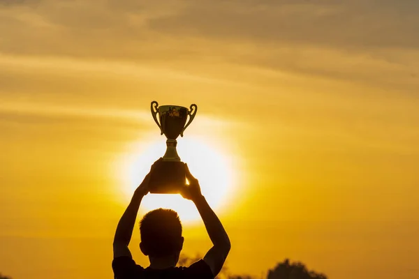 Winner win hands holding golden champion trophy cup prize. Silhouette ...