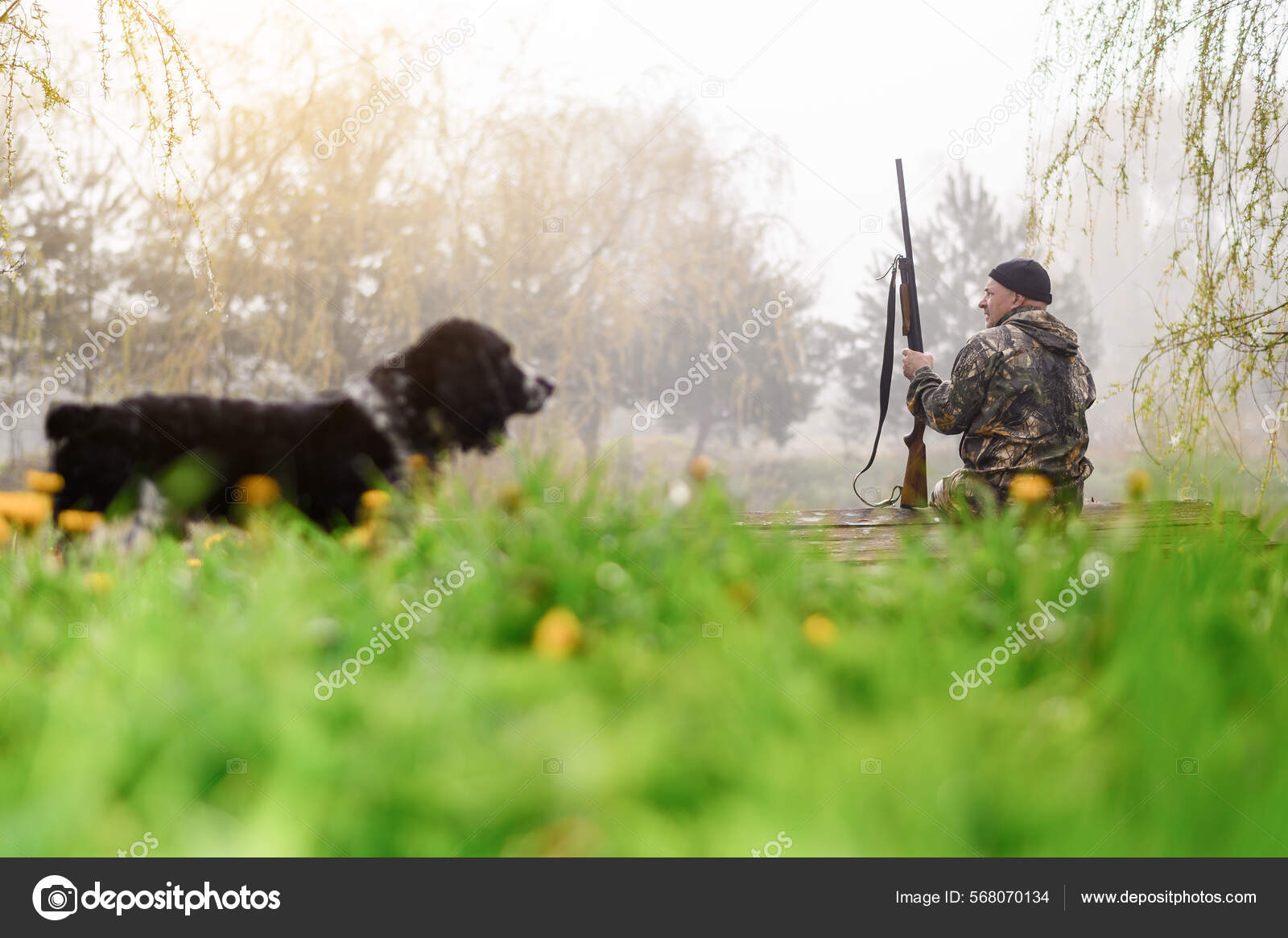 Male hunter sitting on a footbridge on a background of sunrise and ...