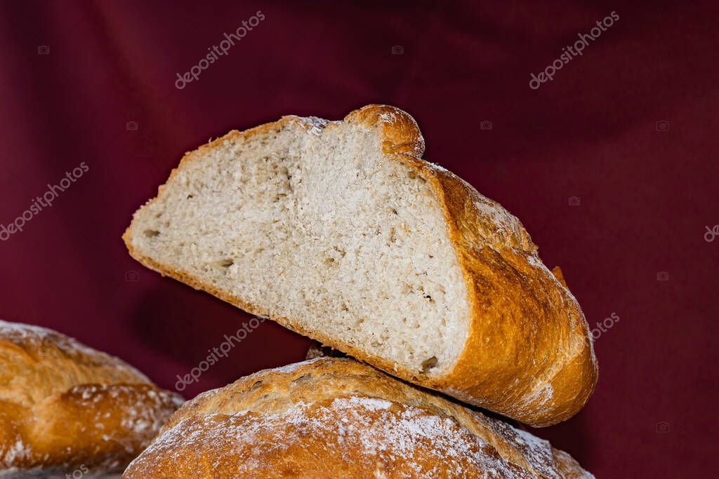 Pan artesano gallego cortado por la mitad con fondo rojo, concepto de ...