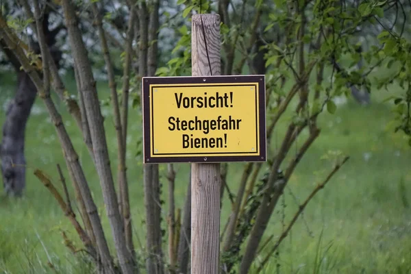 Black and yellow warning sign 'Attention! Danger of stings. Bees!' in ...