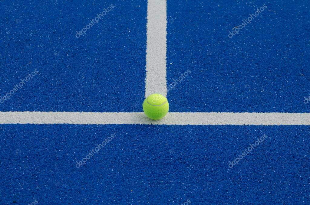 pelota de pádel en la línea de una pista de pádel azul 2023