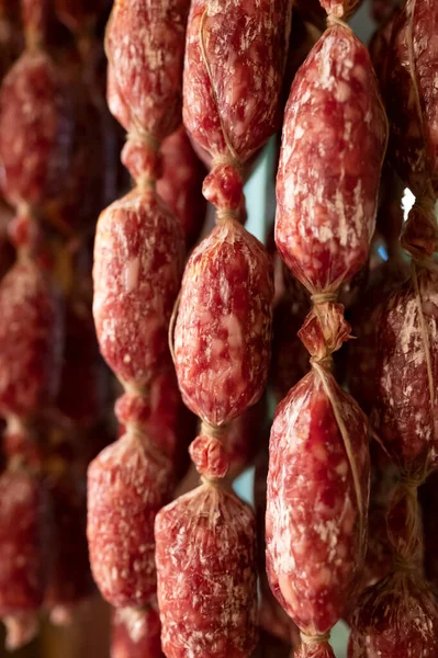 Variety of homemade dried salami sausages hanging in butchery shop in ...
