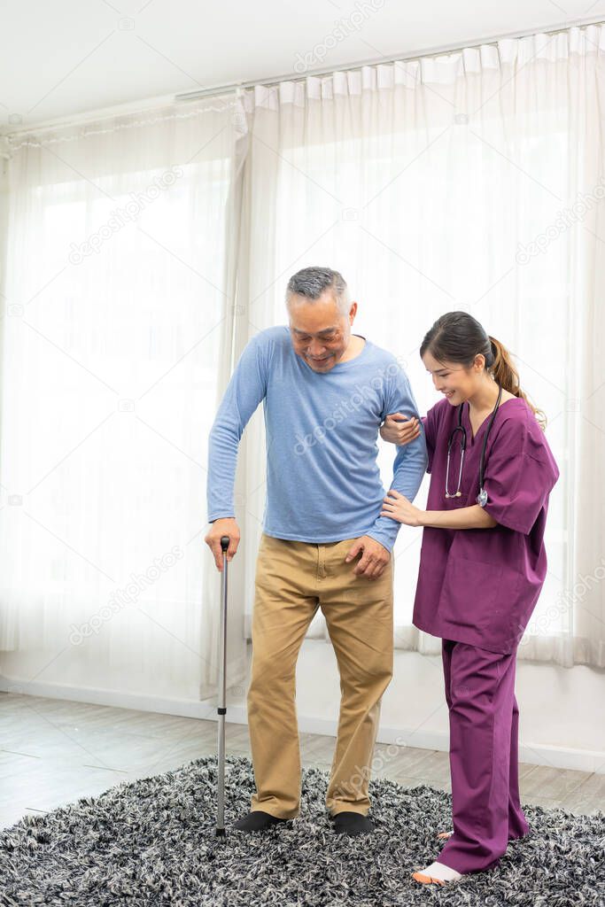 Trabajadora médica ayudando a su paciente a moverse por la casa ...