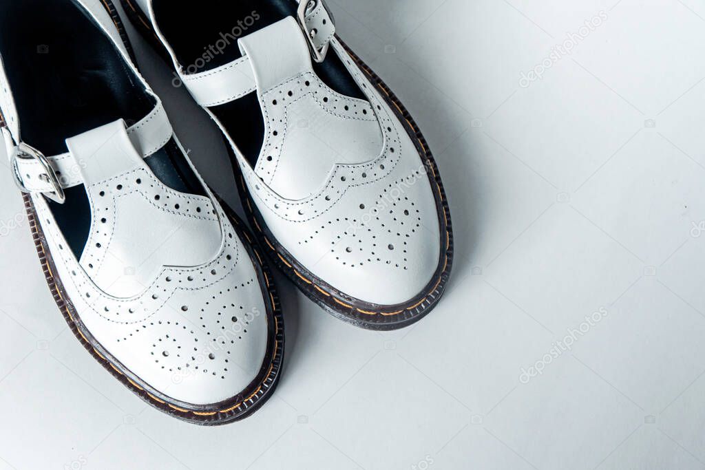 White mary jane shoes with wingtip pattern and rubber sole on a white ...