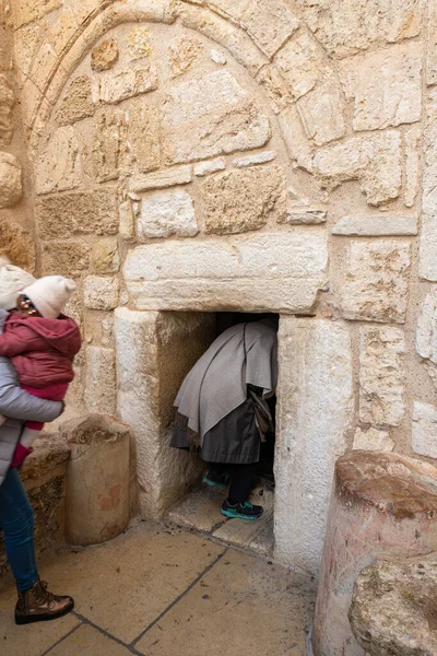 Bethlehem, Israel, December 25, 2021 : Believers and tourists bend down ...
