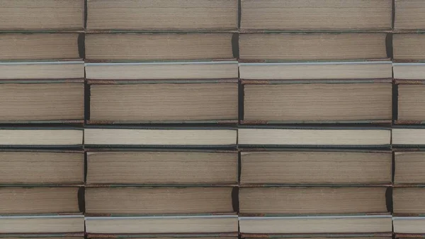 Wall with stacked books. Books one on top of the other with pastes and ...