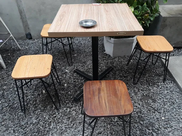 a caf table and chairs with stone floors and plant decorations on the ...