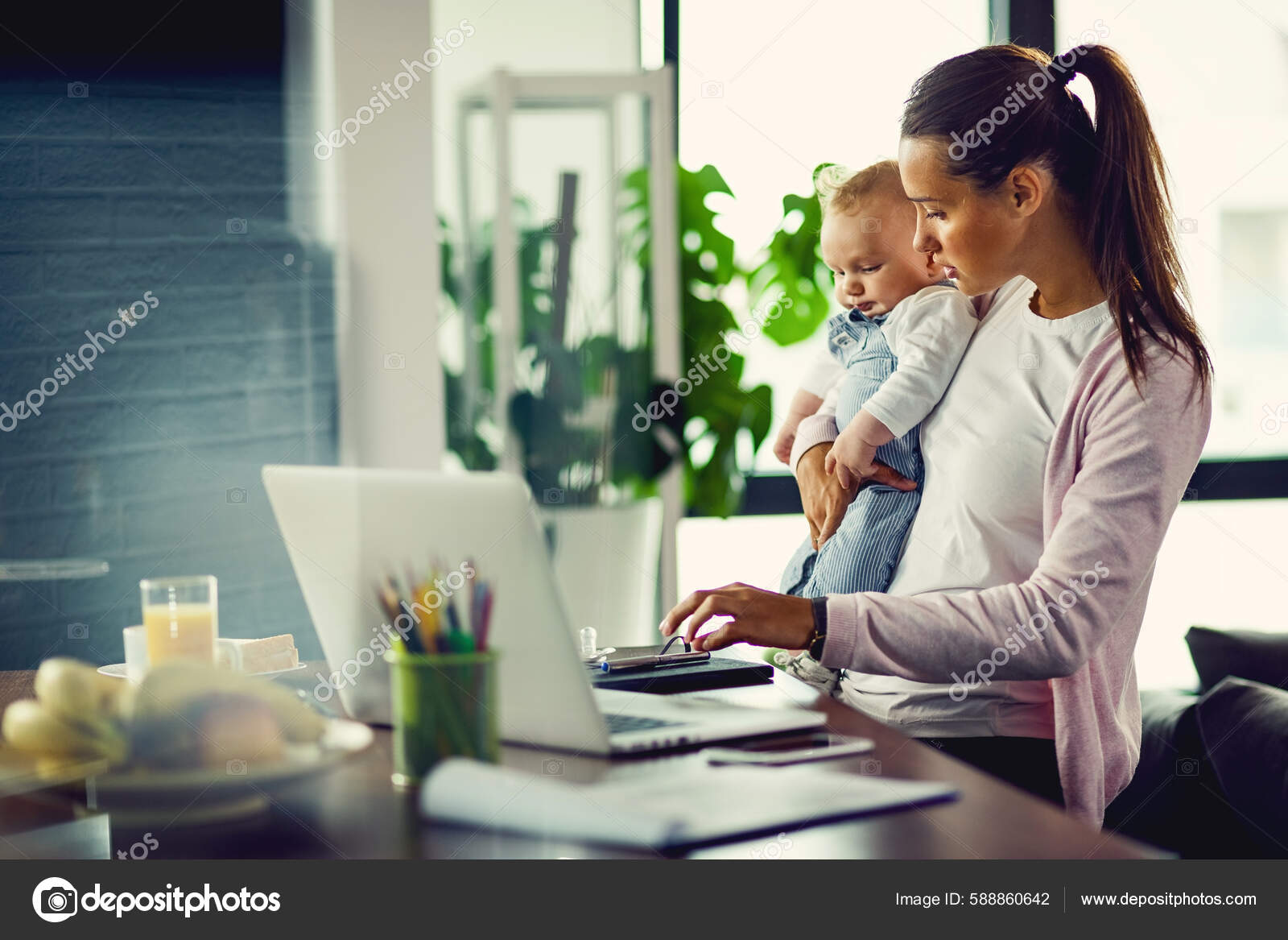Young Working Mother Using Computer While Holding Her Baby Son — Stock ...