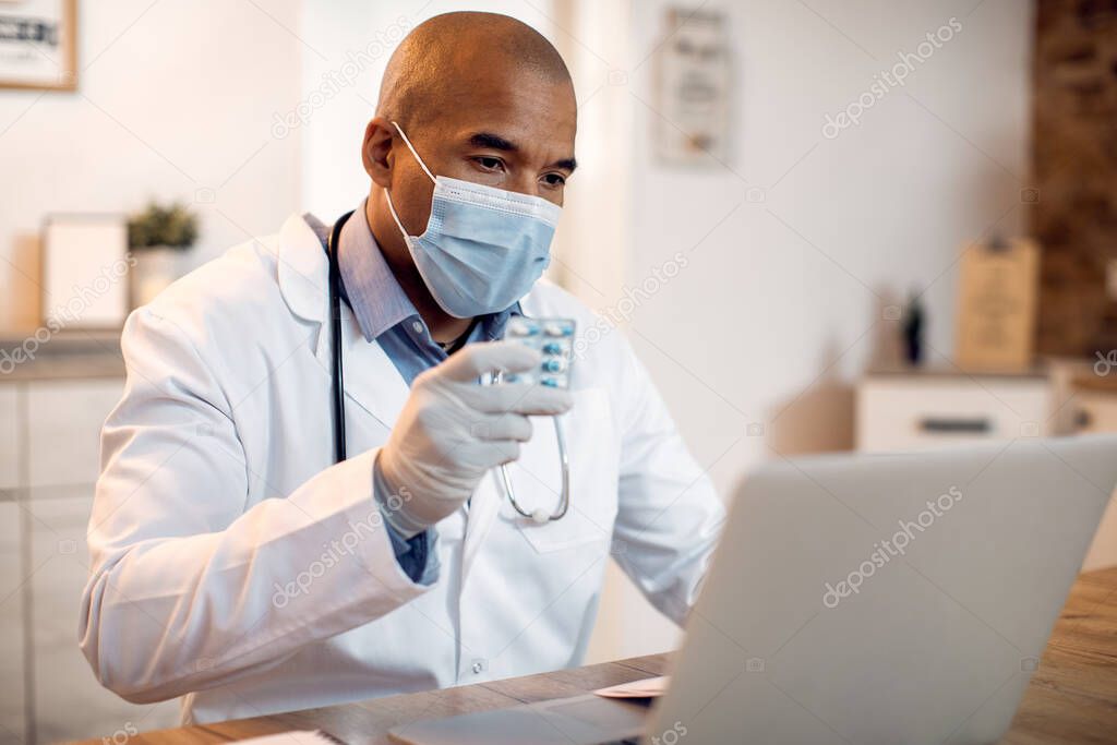 Black doctor using laptop and talking to a patient through video call ...