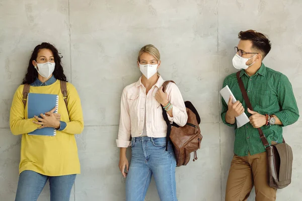 Group of college friends wearing protective face masks while returning ...