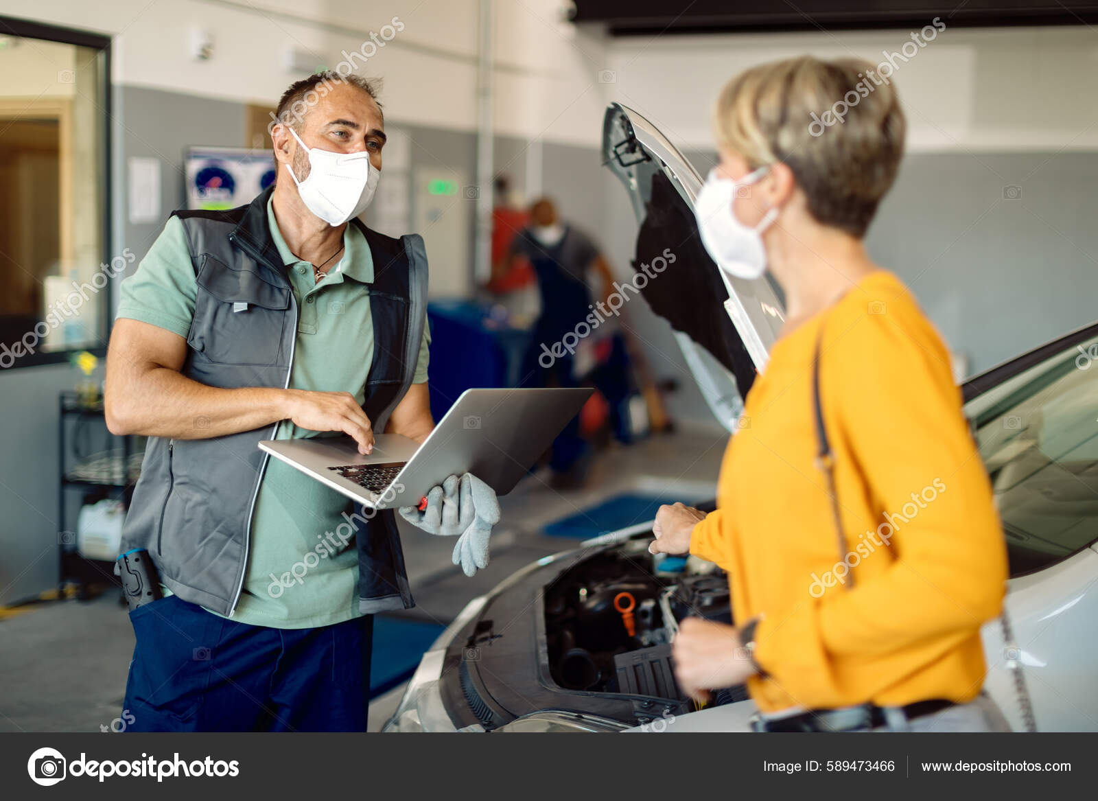 Car Mechanic Communicating Customer While Using Laptop Examining ...
