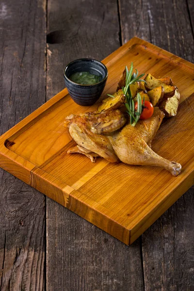 Half fried chicken carcass with rosemary, fried potatoes, cherry ...