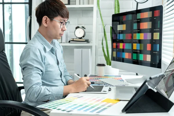 Male graphic designer is choosing color swatch samples on multiple ...