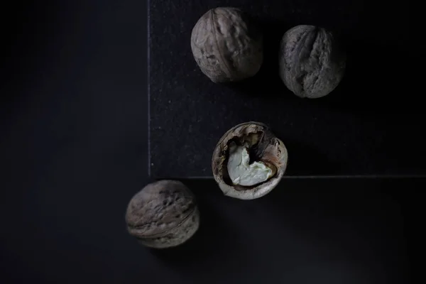 cut walnut tart on a black kitchen cutting board on a black background ...